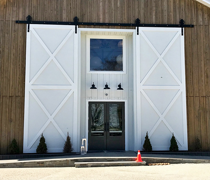The rustic barn-like exterior of The Station on Kings beckons with its striking white barn doors&mdash;architectural simplicity that promises culinary sophistication inside.
