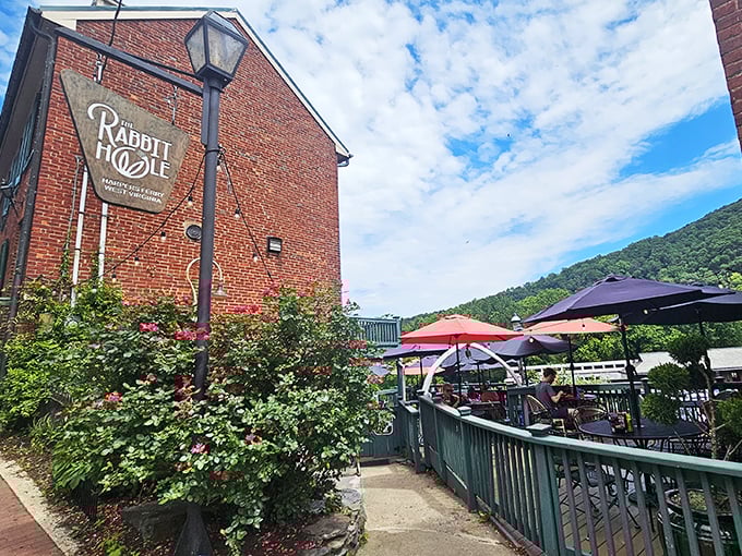 The brick exterior of The Rabbit Hole beckons like a storybook invitation, complete with climbing roses and mountain views that make waiting for a table feel like a vacation.