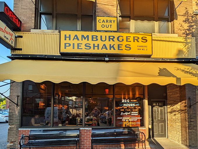 The iconic yellow awning of Hamburg Inn No. 2 beckons like a breakfast lighthouse on Linn Street, promising pieshakes and happiness since 1948.