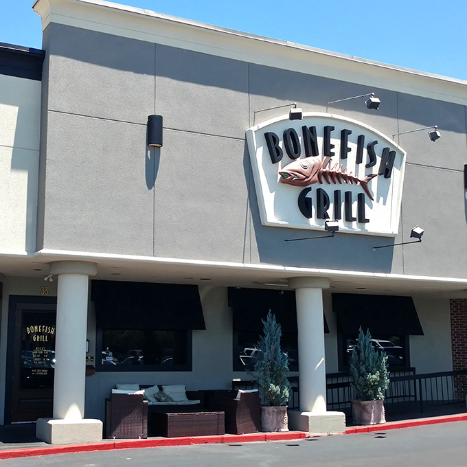 The iconic Bonefish Grill facade stands like a beacon for seafood lovers, its distinctive fish skeleton sign promising aquatic delights within.