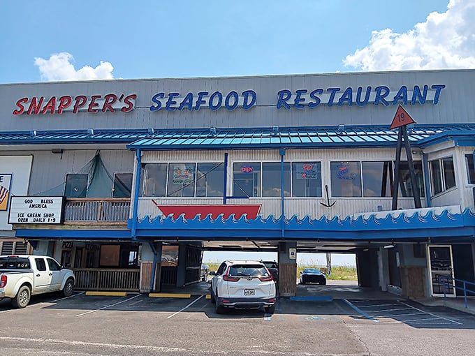Snapper's iconic blue-trimmed exterior stands like a beacon for seafood lovers, with parking cleverly tucked underneath&mdash;Gulf Coast practicality at its finest.