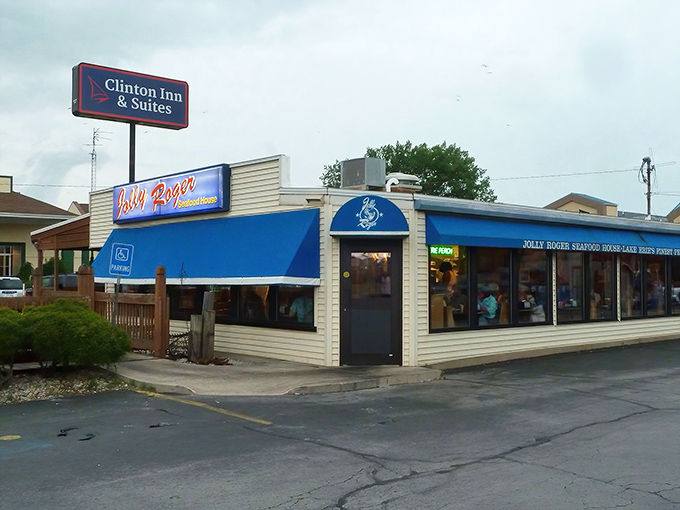 The blue awning of Jolly Rogers stands like a maritime beacon in Port Clinton, promising seafood treasures within its unassuming exterior.