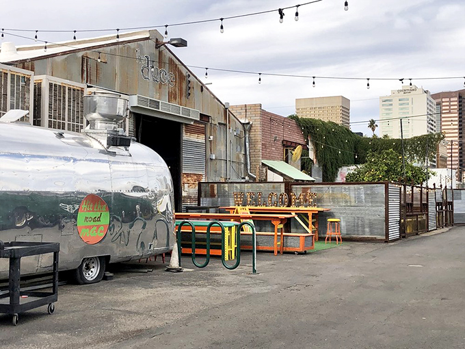 The Duce's exterior is industrial chic personified—corrugated metal, vintage signage, and that gleaming Airstream trailer promising culinary adventures within.