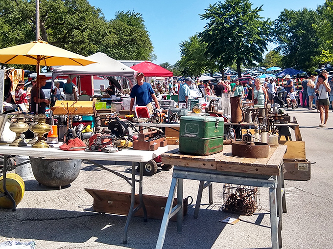 The Sunday morning pilgrimage begins! Treasure hunters navigate the sprawling aisles of Wentzville Flea Market under Missouri's brilliant blue skies.