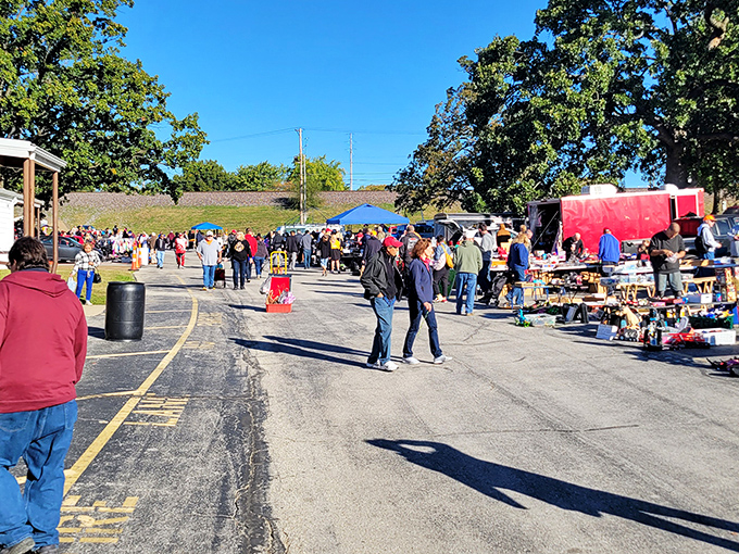 The Sunday morning pilgrimage begins! Treasure hunters navigate the sprawling aisles of Wentzville Flea Market under Missouri's brilliant blue skies.