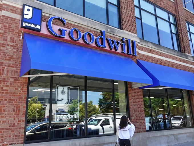 The iconic blue awnings of Goodwill beckon like a retail oasis in Chicago's urban landscape, promising treasures within those brick walls.