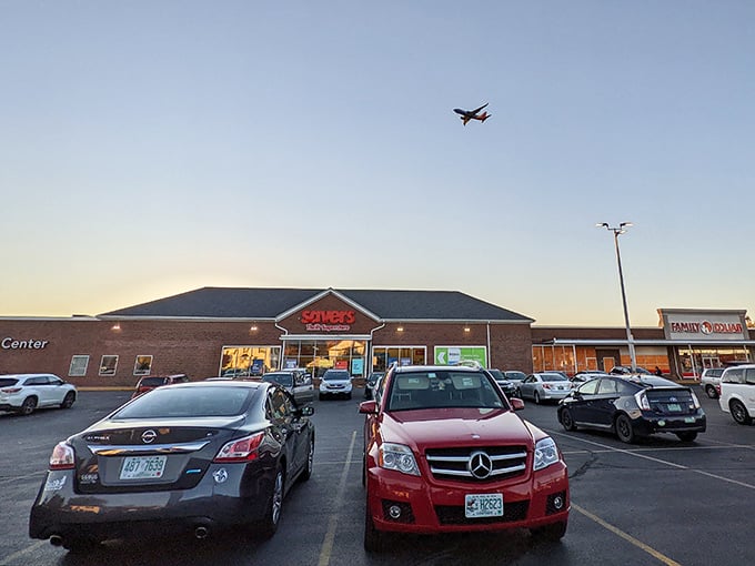 The Savers storefront at dusk, where budget dreams take flight alongside that airplane in the background. Treasure hunting season is always open here.