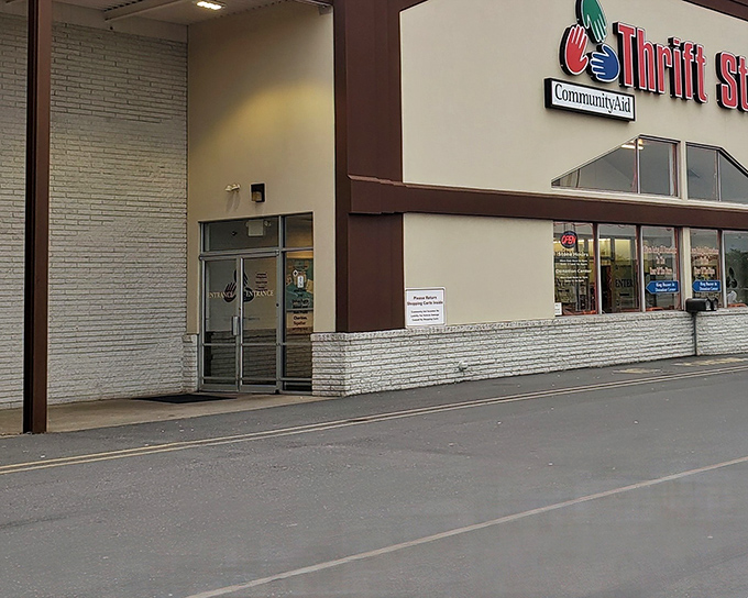 The red signage beckons like a lighthouse to bargain hunters. CommunityAid's exterior promises treasure hunting adventures within those unassuming walls.