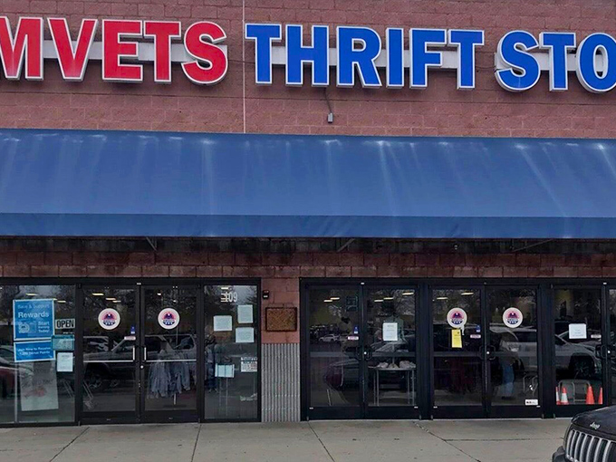 The blue awning beckons like a portal to bargain paradise. AMVETS Thrift Store's unassuming exterior hides treasures waiting to be discovered.