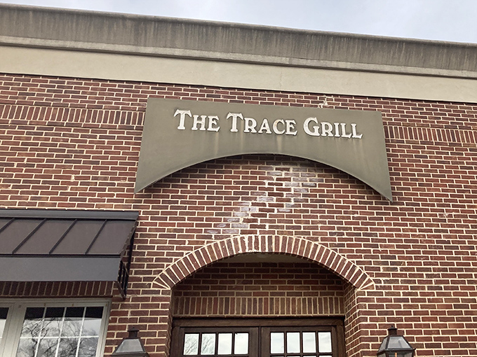 The unassuming brick exterior of The Trace Grill hides culinary treasures within, like a Southern speakeasy where the password is "comfort food."