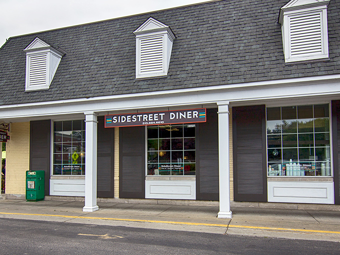 The charming yellow brick exterior of Side Street Diner beckons with its distinctive mansard roof and welcoming entrance. A hidden gem worth seeking out!