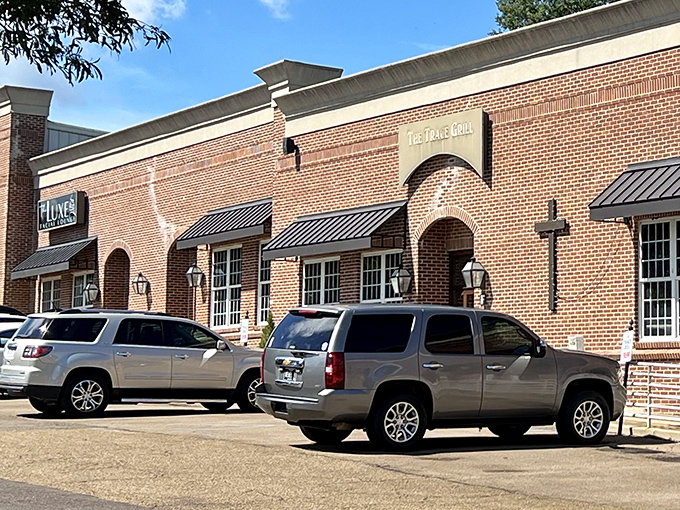 The unassuming brick exterior of The Trace Grill hides culinary treasures within, like a Southern speakeasy where the password is "comfort food."
