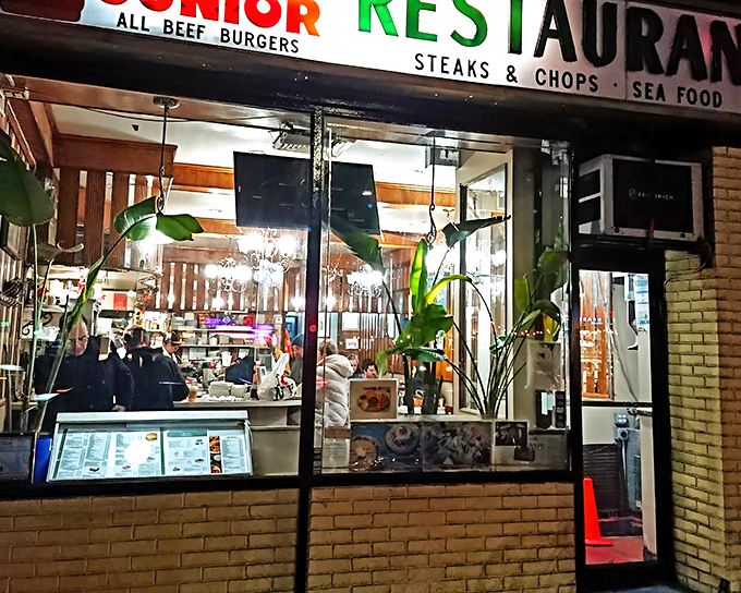 The iconic Joe Jr. sign promises three essential food groups: all-beef burgers, steaks & chops, and seafood. Classic New York diner perfection awaits inside.