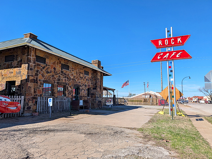 The iconic stone exterior of Rock Cafe stands as a Route 66 sentinel, complete with vintage car cutouts that practically wink at passing travelers.