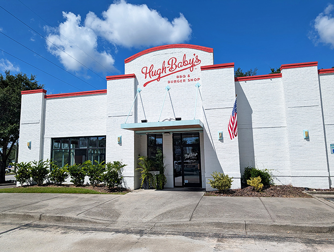 Hugh-Baby's white brick exterior with its bold red signage stands like a culinary lighthouse, beckoning hungry travelers with promises of Southern comfort.