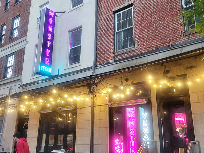 The neon-lit entrance to Monster Vegan beckons like a pink-hued beacon for the hungry and curious. Metal tables outside offer a perfect people-watching perch.