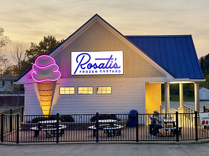 Rosati's glows like a frozen dessert lighthouse at dusk, its neon ice cream cone beckoning weary travelers toward sweet salvation.