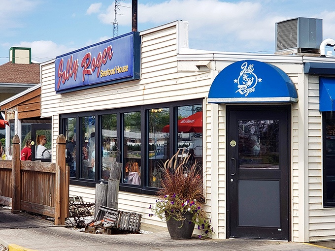 The blue awning of Jolly Rogers stands like a maritime beacon in Port Clinton, promising seafood treasures within its unassuming exterior.