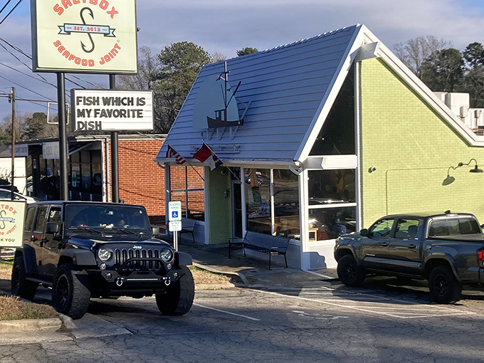The humble exterior of Saltbox Seafood Joint belies the culinary treasures within. That "NC SEAFOOD" sign is basically a bat signal for hungry North Carolinians.