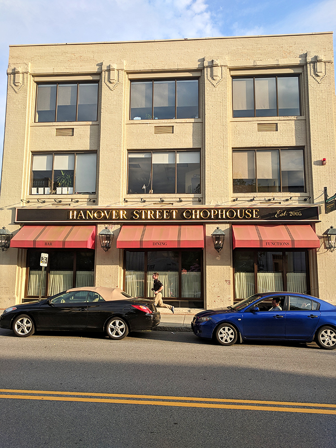 The iconic red awning beckons like a culinary lighthouse, promising refuge from ordinary dining experiences in downtown Manchester.