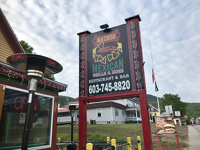The yellow and red exterior of Nachos Mexican Bar and Grill stands out like a sombrero at a ski lodge, beckoning hungry travelers with its vibrant charm.