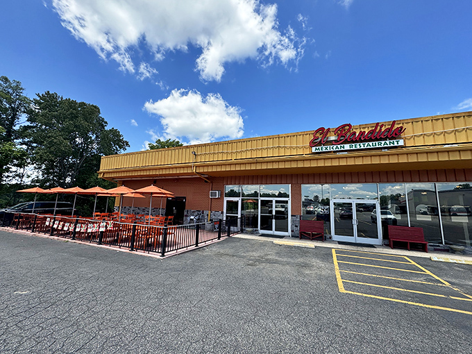 The golden glow of El Bandido's exterior promises culinary treasures within. Those red benches aren't just seating&mdash;they're the waiting room for flavor paradise.
