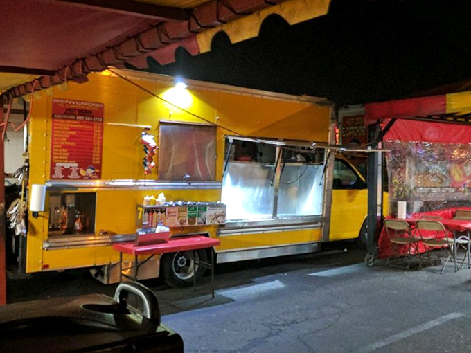 The humble chariot of flavor! El Caprichoso's colorful food cart promises bacon-wrapped bliss that's worth every minute in line.
