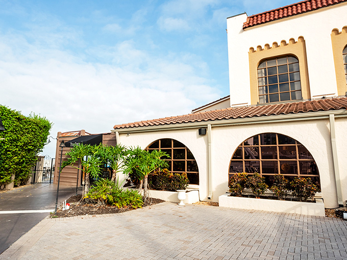 Mediterranean elegance meets Florida sunshine at PIER 22's entrance, where palm trees stand guard and the promise of waterfront dining beckons.
