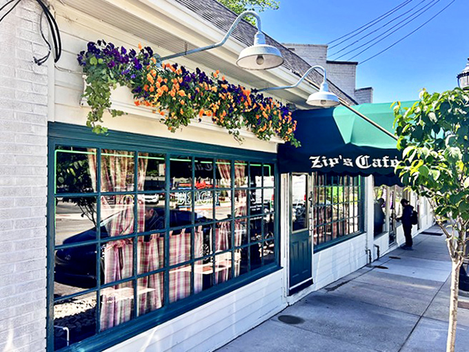 The unassuming white brick exterior of Zip's Cafe, with its signature green awning, proves that culinary greatness rarely needs flashy advertising.