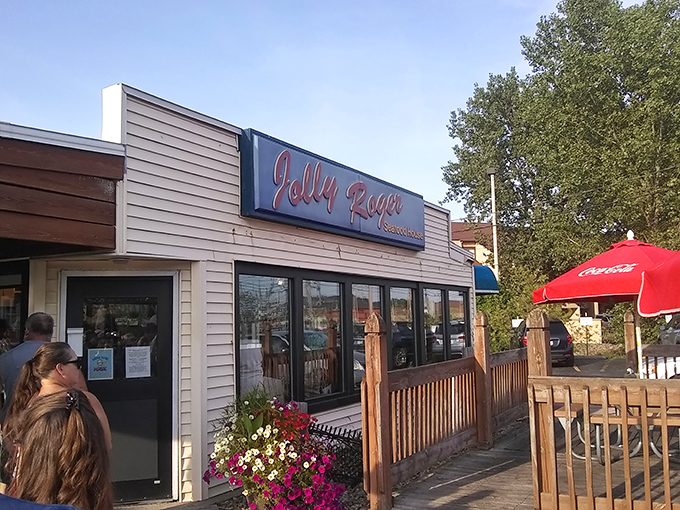 The unassuming exterior of Jolly Rogers beckons like a lighthouse to hungry travelers. Those red umbrellas promise summer delights regardless of the season.