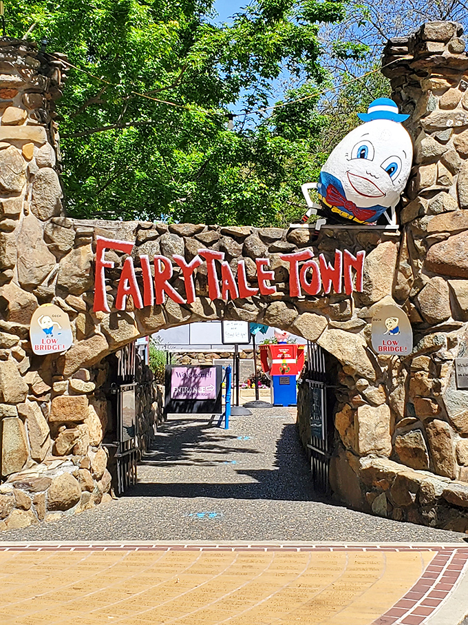 The stone archway entrance to Fairytale Town welcomes visitors with Humpty Dumpty perched above, proving some falls can lead to happy endings after all.