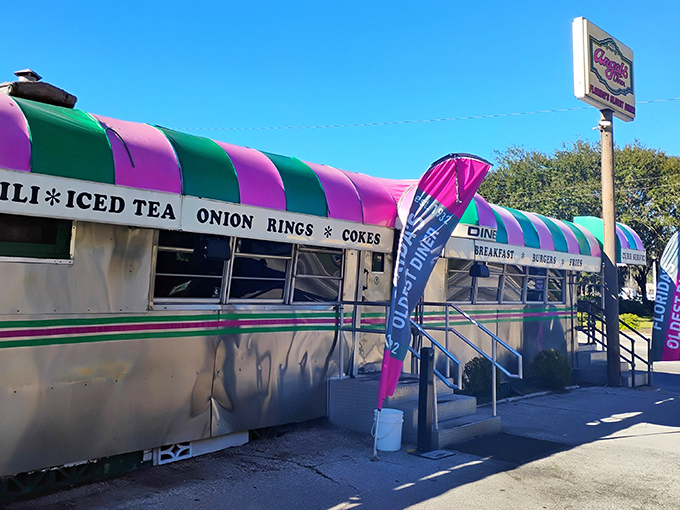 The unmistakable pink and green striped awning of Angel's Dining Car stands as a colorful beacon for hungry travelers in Palatka, welcoming visitors since 1932.