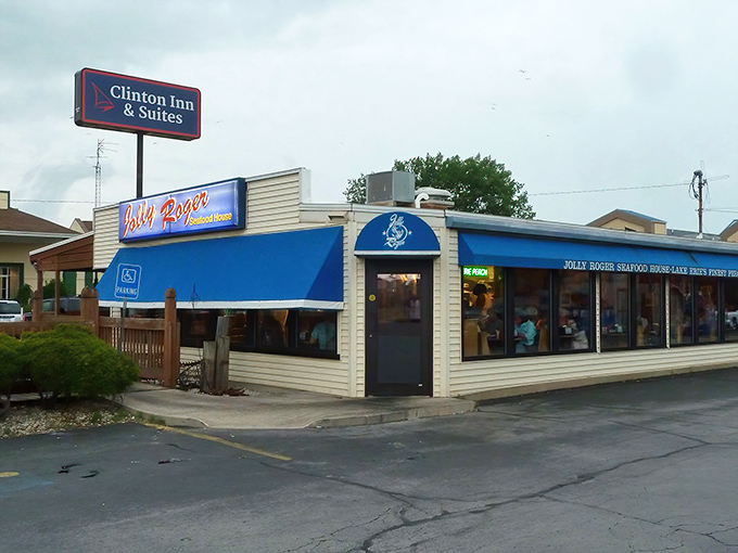 The blue awning of Jolly Rogers stands like a maritime beacon in Port Clinton, promising seafood treasures within its unassuming exterior.