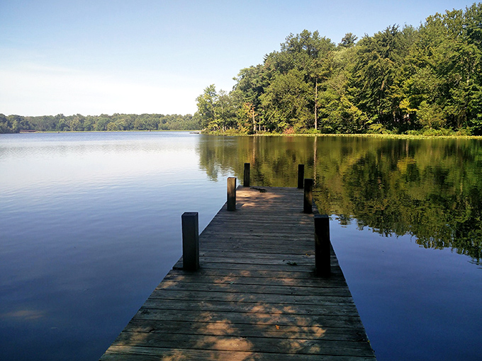 The wooden dock at Lincoln State Park invites contemplation as it stretches into the glassy waters, offering a front-row seat to nature's daily masterpiece.