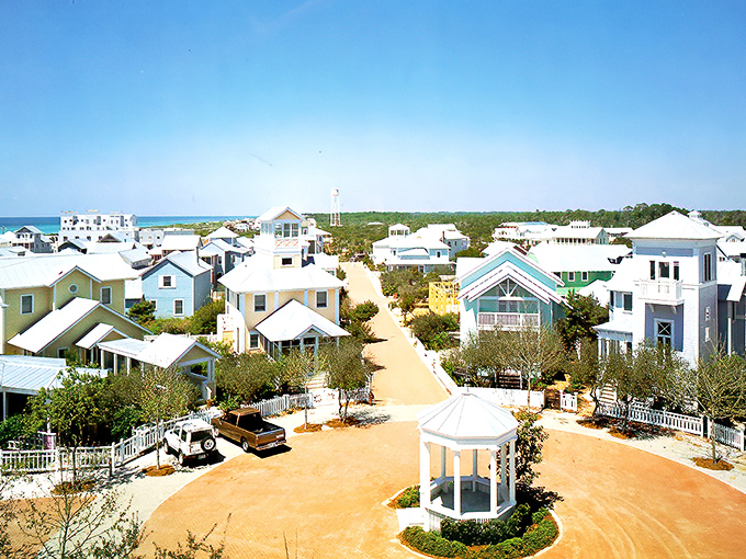 Aerial perfection: Seaside's master-planned paradise unfolds like a storybook from above, where emerald waters meet pristine white beaches and pastel-colored cottages create a living watercolor.
