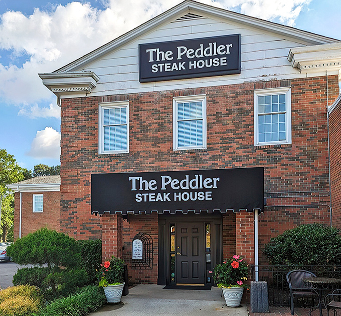 The brick façade of The Peddler stands like a carnivore's lighthouse, beckoning hungry travelers with its classic steakhouse promise. Some buildings just look delicious.