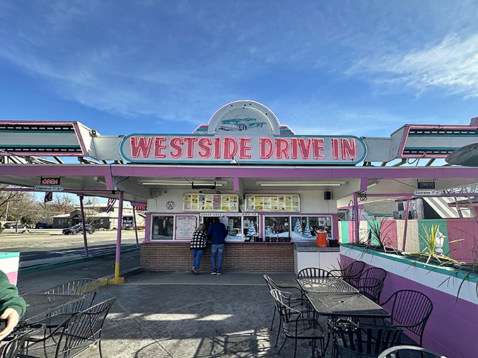 The pink and turquoise facade of Westside Drive In stands like a time capsule of Americana, beckoning hungry travelers with promises of comfort food perfection.