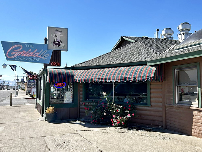 The iconic blue neon sign beckons hungry travelers like a desert oasis. This log cabin diner on Winnemucca's main drag promises comfort food salvation.