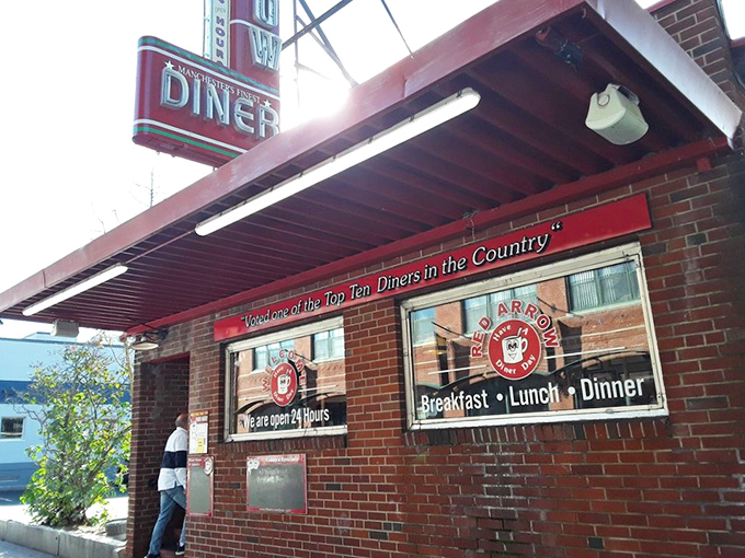 The iconic Red Arrow Diner sign beckons hungry travelers like a neon lighthouse, promising salvation from hunger in downtown Manchester.