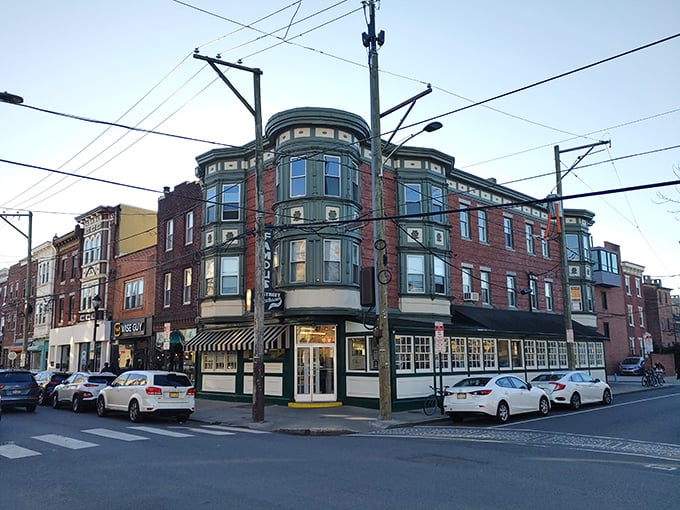 The iconic brick corner building housing Famous 4th Street Delicatessen stands like a time capsule in Philadelphia's Queen Village. Green-trimmed windows hint at the culinary treasures within.