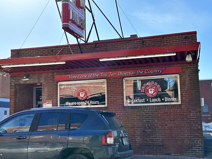 The iconic Red Arrow Diner sign beckons hungry travelers like a neon lighthouse, promising salvation from hunger in downtown Manchester.