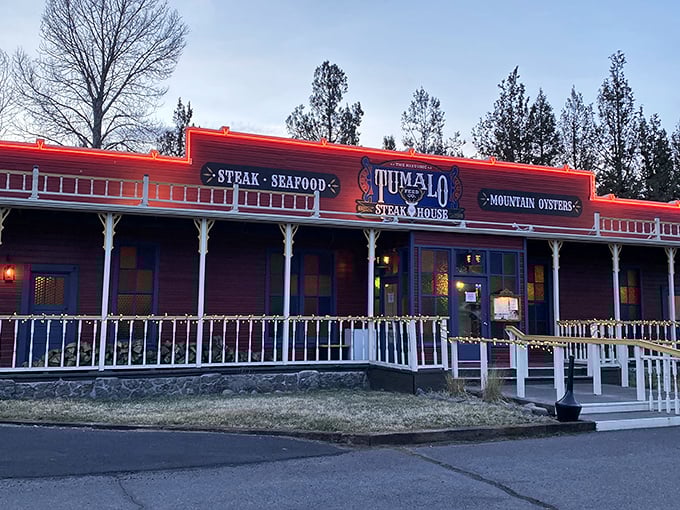 The iconic red facade of Tumalo Feed Co. stands proudly against the Oregon sky, a rustic time machine beckoning hungry travelers with its Western charm and promise of carnivorous delights.