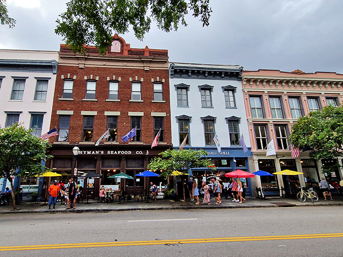The iconic blue storefront of Hyman's glows with promise as evening falls, flags fluttering like a patriotic welcome committee for hungry visitors.