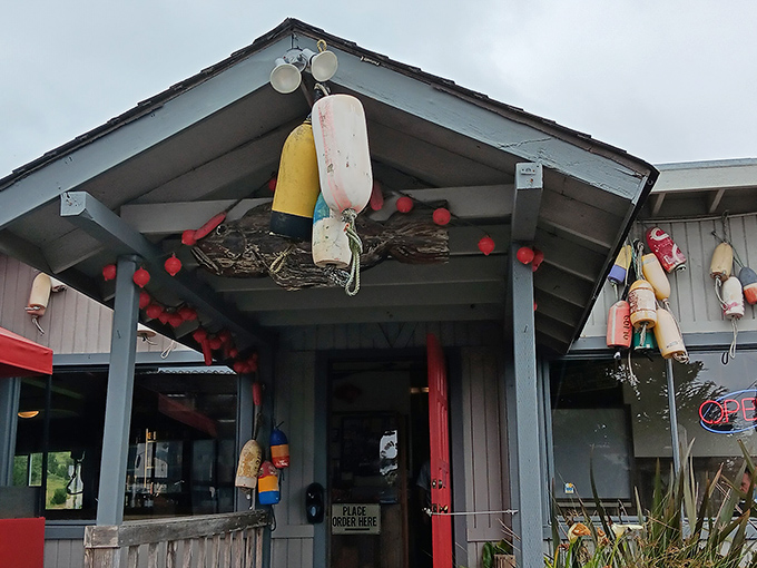 Maritime charm meets culinary treasure at The Boat House's exterior, where colorful buoys and fishing floats hint at the ocean-fresh delights waiting inside.