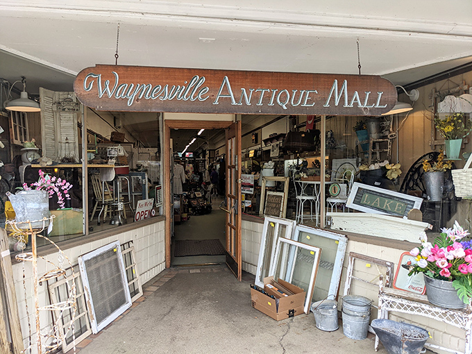 The storefront beckons with vintage charm, that iconic vertical "ANTIQUES" sign practically whispering, "Come in, your grandmother's favorite lamp is waiting for you."