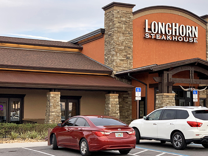 The Western-inspired facade of LongHorn Steakhouse stands like a carnivore's oasis amid Orlando's tourist landscape, promising refuge for the steak-starved traveler.
