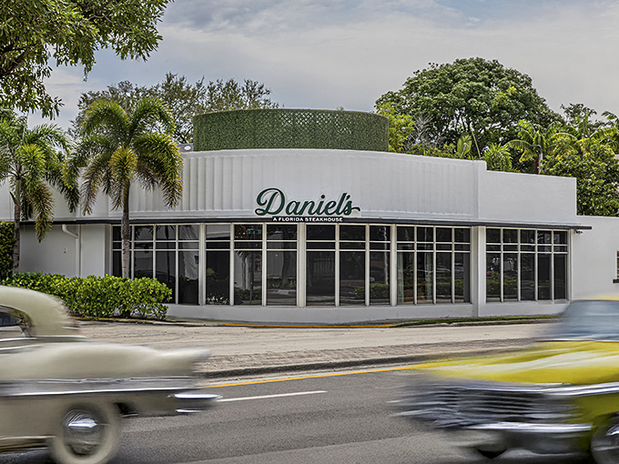 Art Deco elegance meets steakhouse sophistication at Daniel's, where the striking white exterior promises culinary adventures within. Palm trees included, no extra charge.