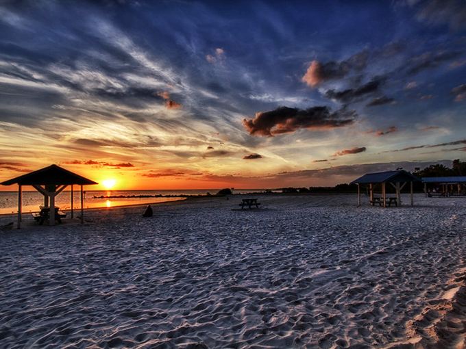 Dramatic storm clouds create a moody backdrop over Fort Island Beach, where the Gulf waters meet pristine shoreline in a perfect Florida moment.