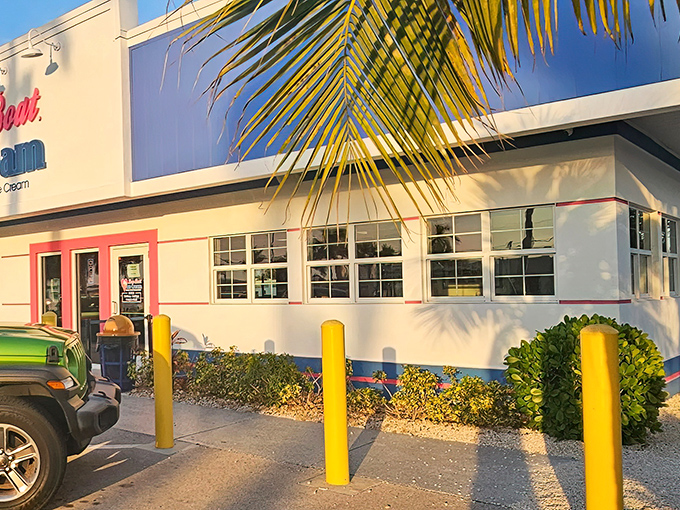 The bright blue and pink exterior of Love Boat Ice Cream stands out like a tropical oasis in the Florida heat, complete with a whimsical boat logo that promises sweet adventures ahead.