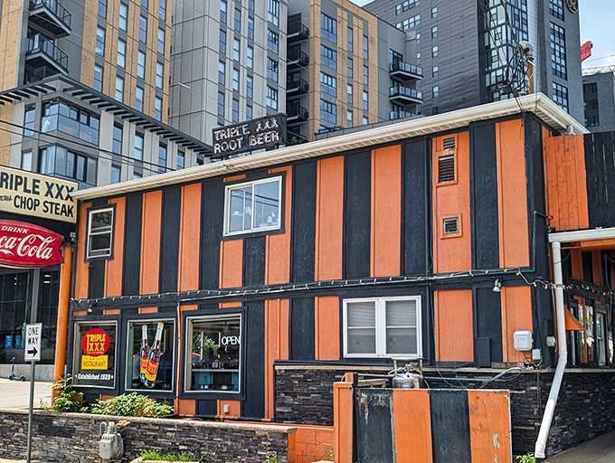 The unmistakable orange and black stripes of Triple XXX stand as a beacon to hungry travelers, promising nostalgic flavors and Hoosier hospitality at Indiana's oldest drive-in.